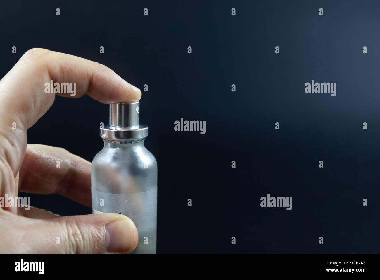 Picture of a small perfume bottle spraying fragrance, being pushed by ...