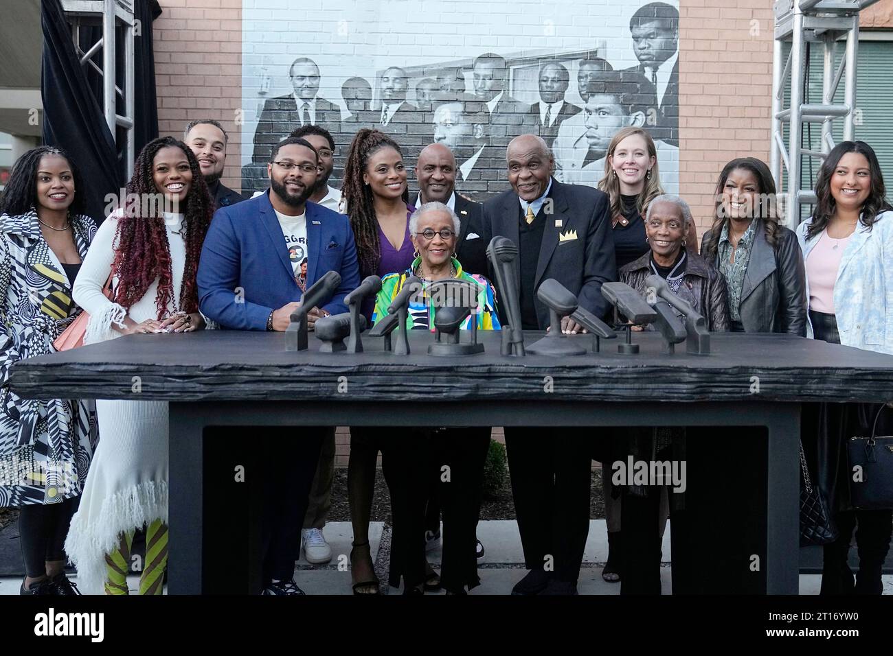 Participants pose for a photo behind a sculpture commemorating the 1967 ...