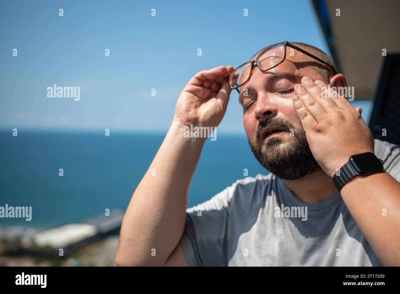 Bald fat man drenched in sweat wiped off excess moisture. Sweating ...