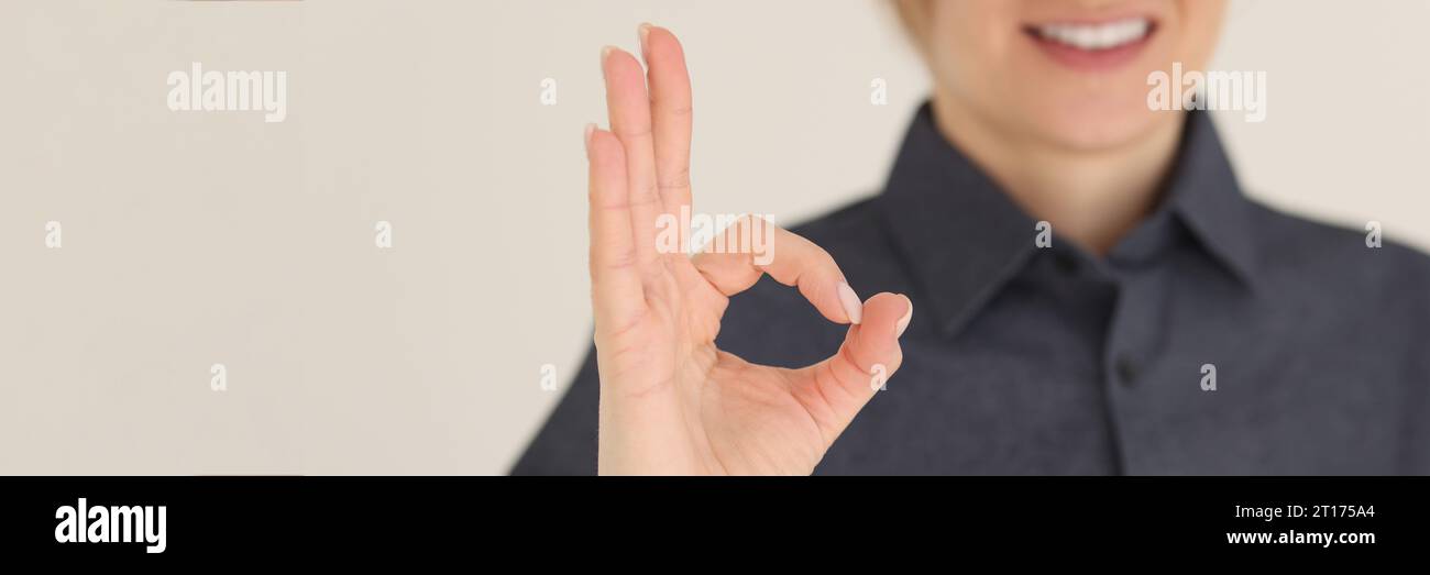Cheerful woman shows OK symbol with hand smiling on beige Stock Photo - Alamy
