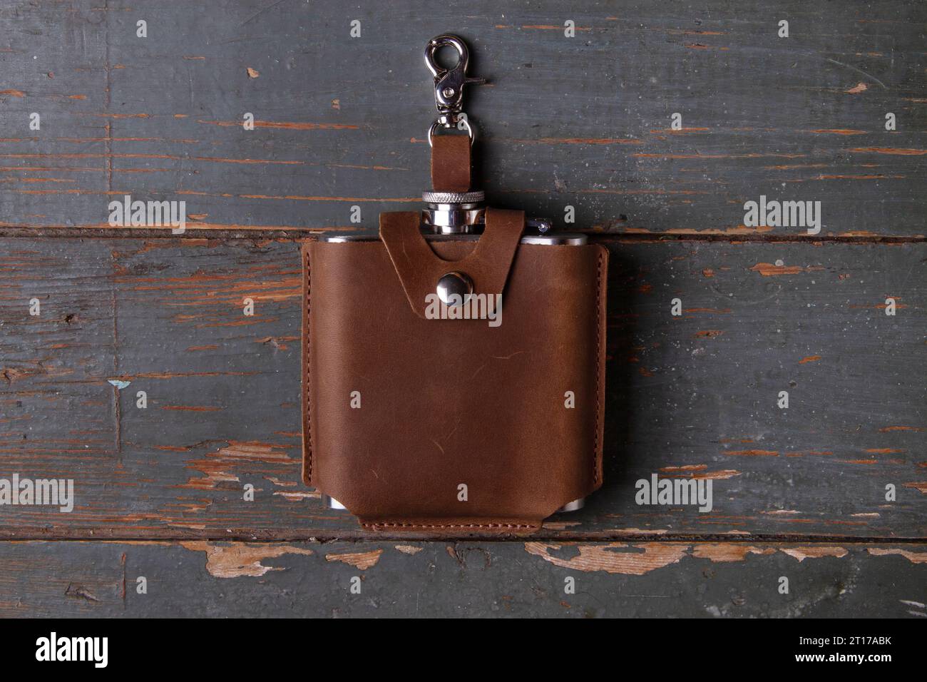Hip flask in full grain leather Hip flask case on wooden tabletop Stock ...