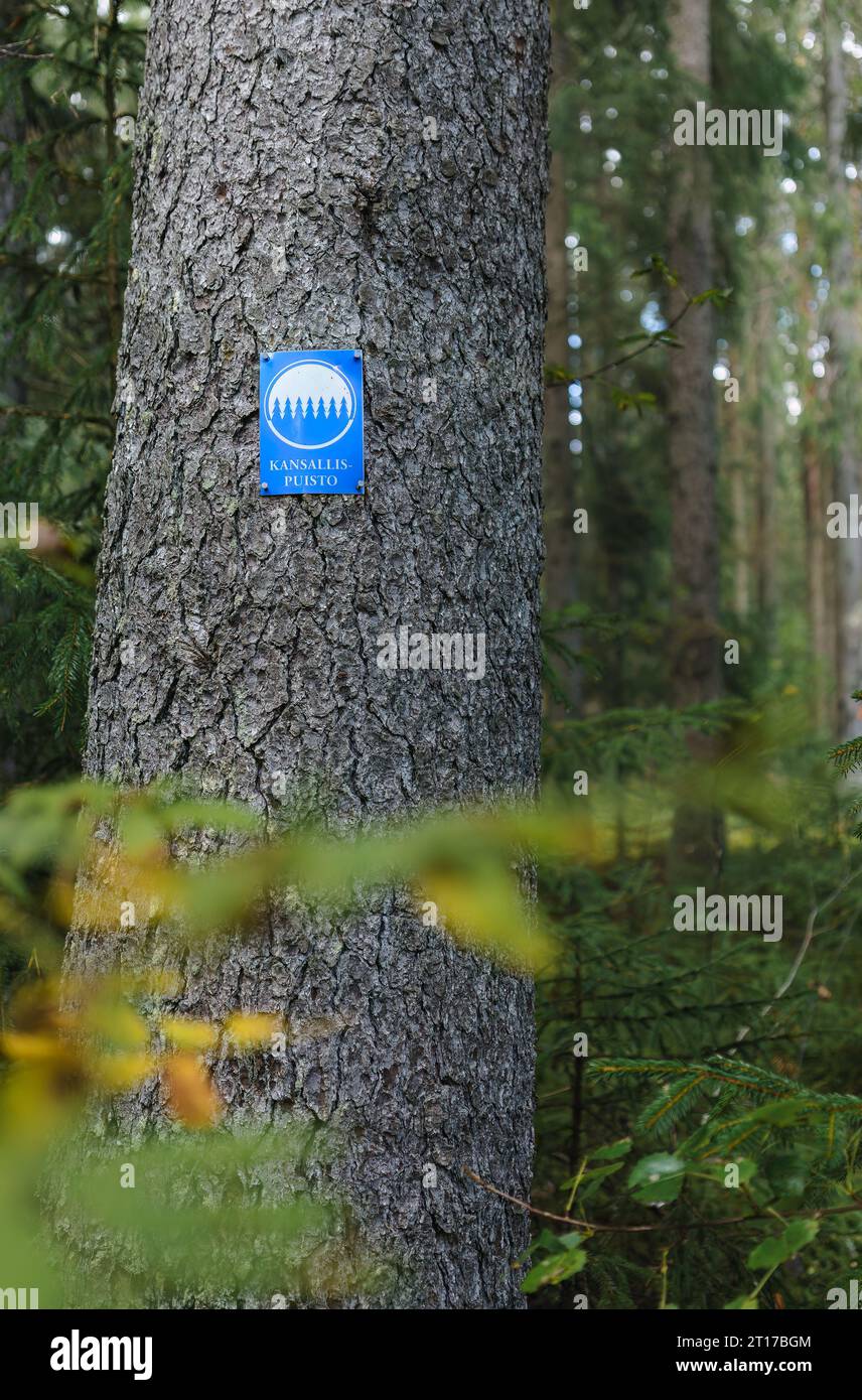 Blue kansallispuisto sign (Finnish for National Park) on a pine tree in ...