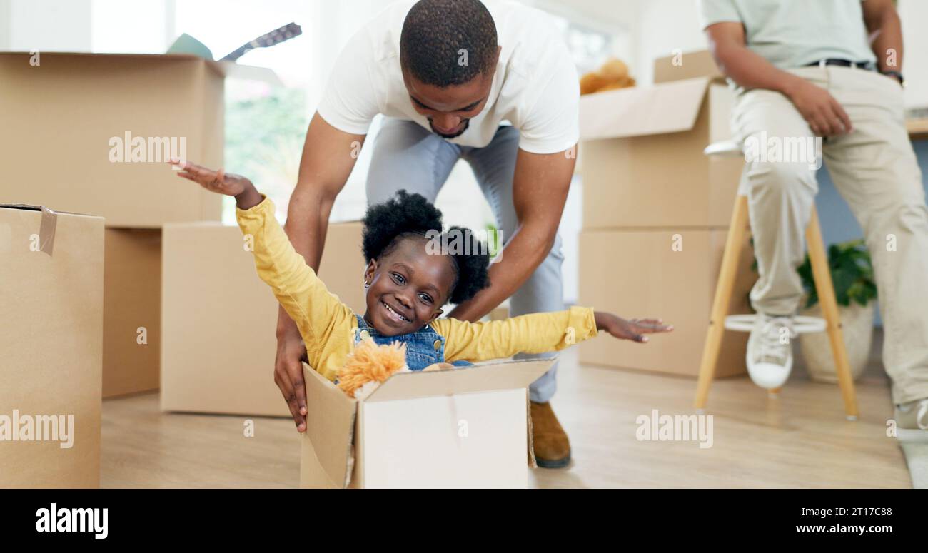 Father, playing and child in a box while moving house with a black ...