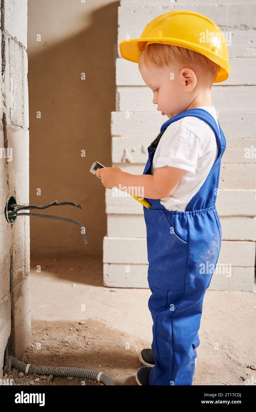 Adorable child construction worker using wire stripper cutter tool ...