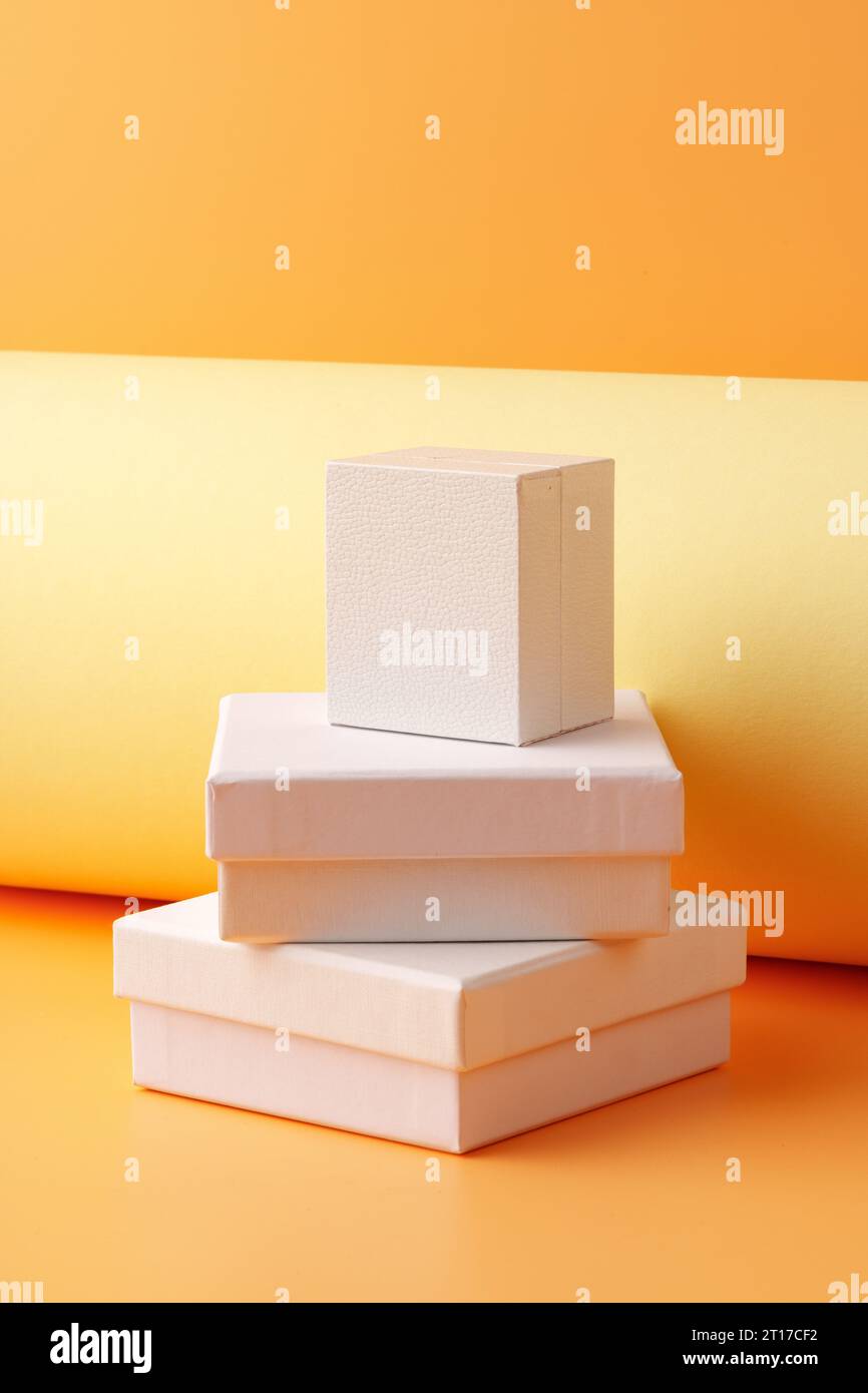 Three closed white jewelry boxes on yellow background Stock Photo - Alamy