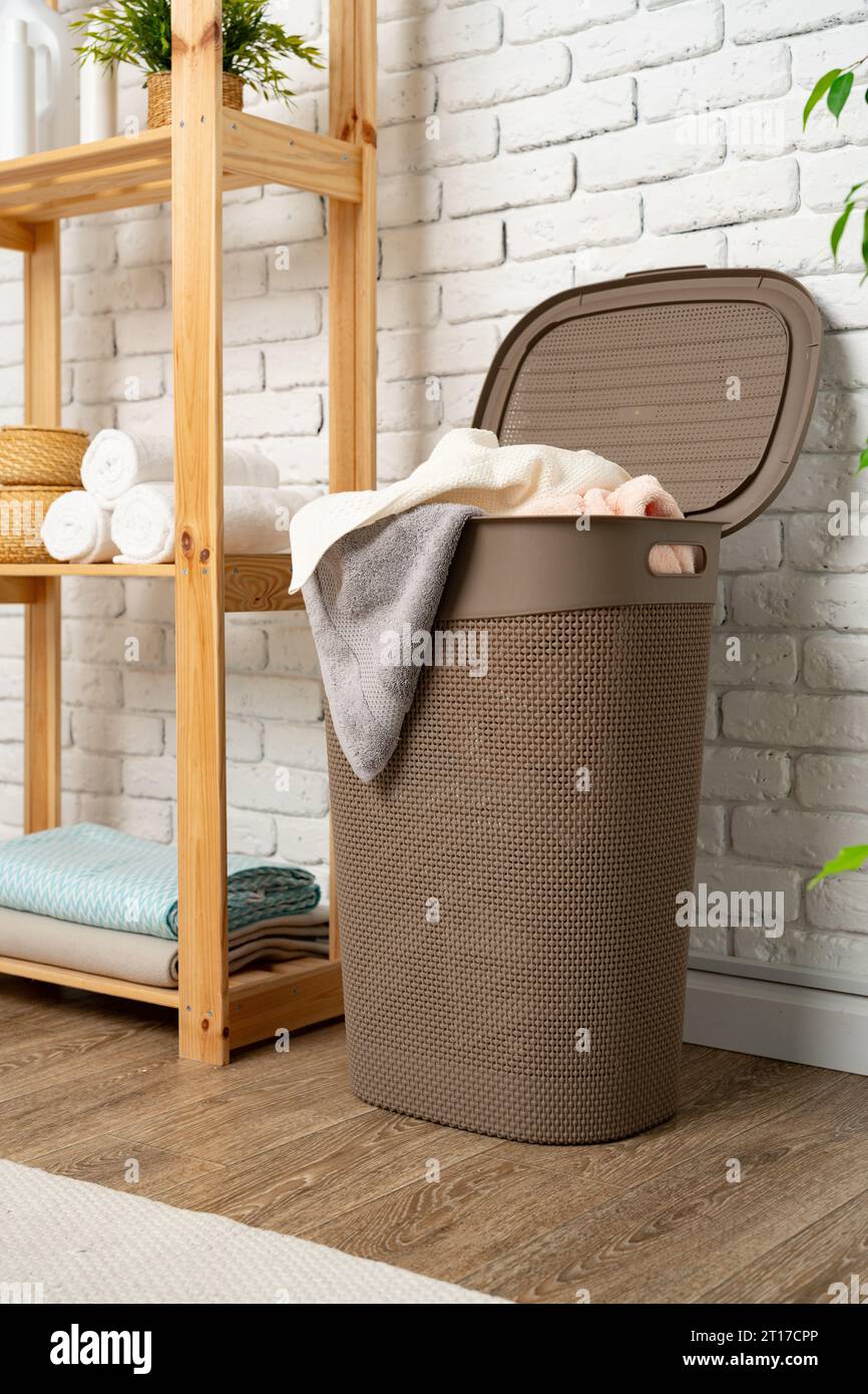 Pile of clothes in plastic laundry basket in the bathroom Stock Photo ...