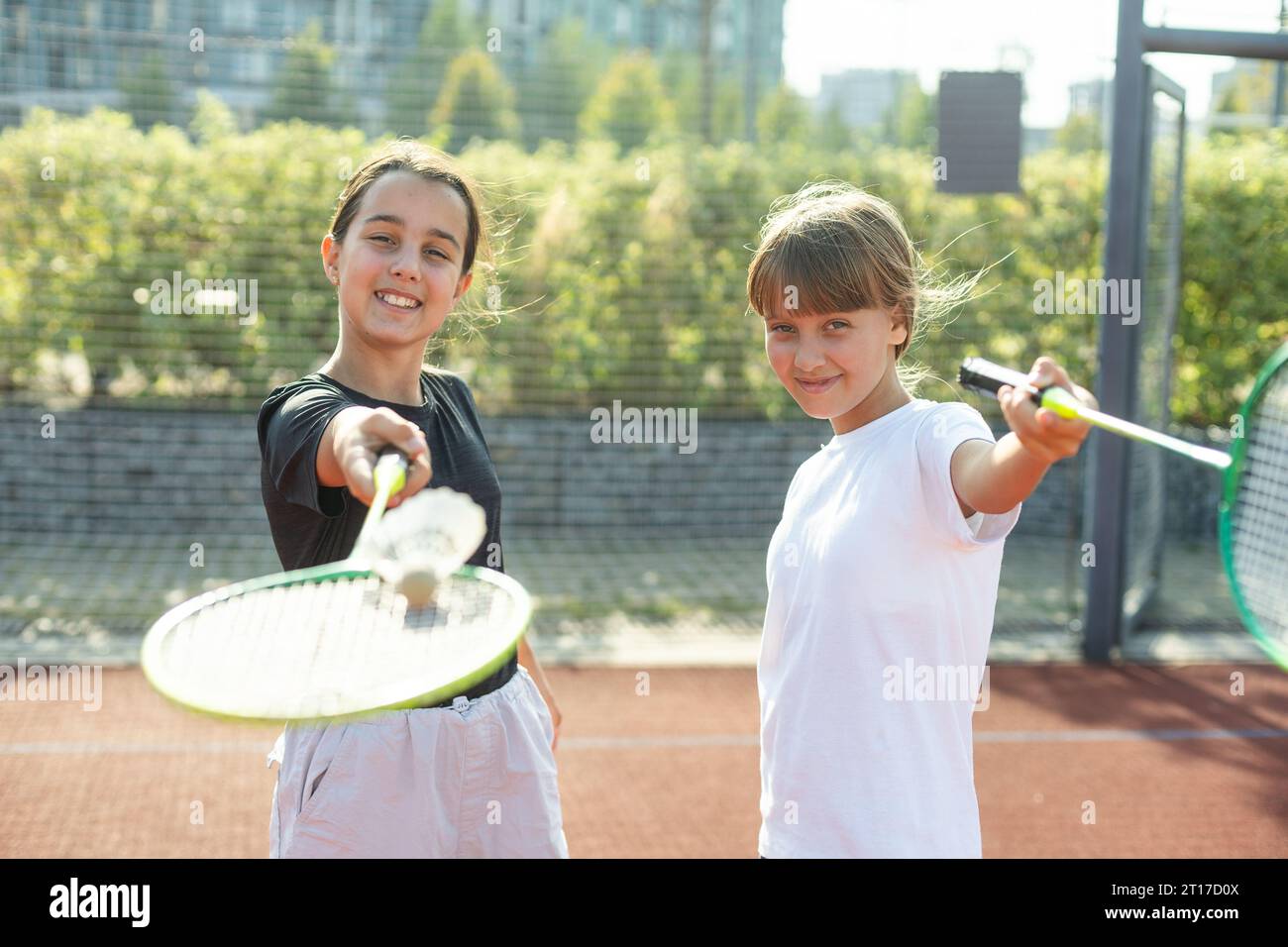 Happy sporty elementary school age girl, child playing badminton ...