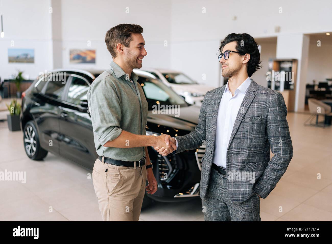 Side view of confident dealer wearing business suit and cheerful ...