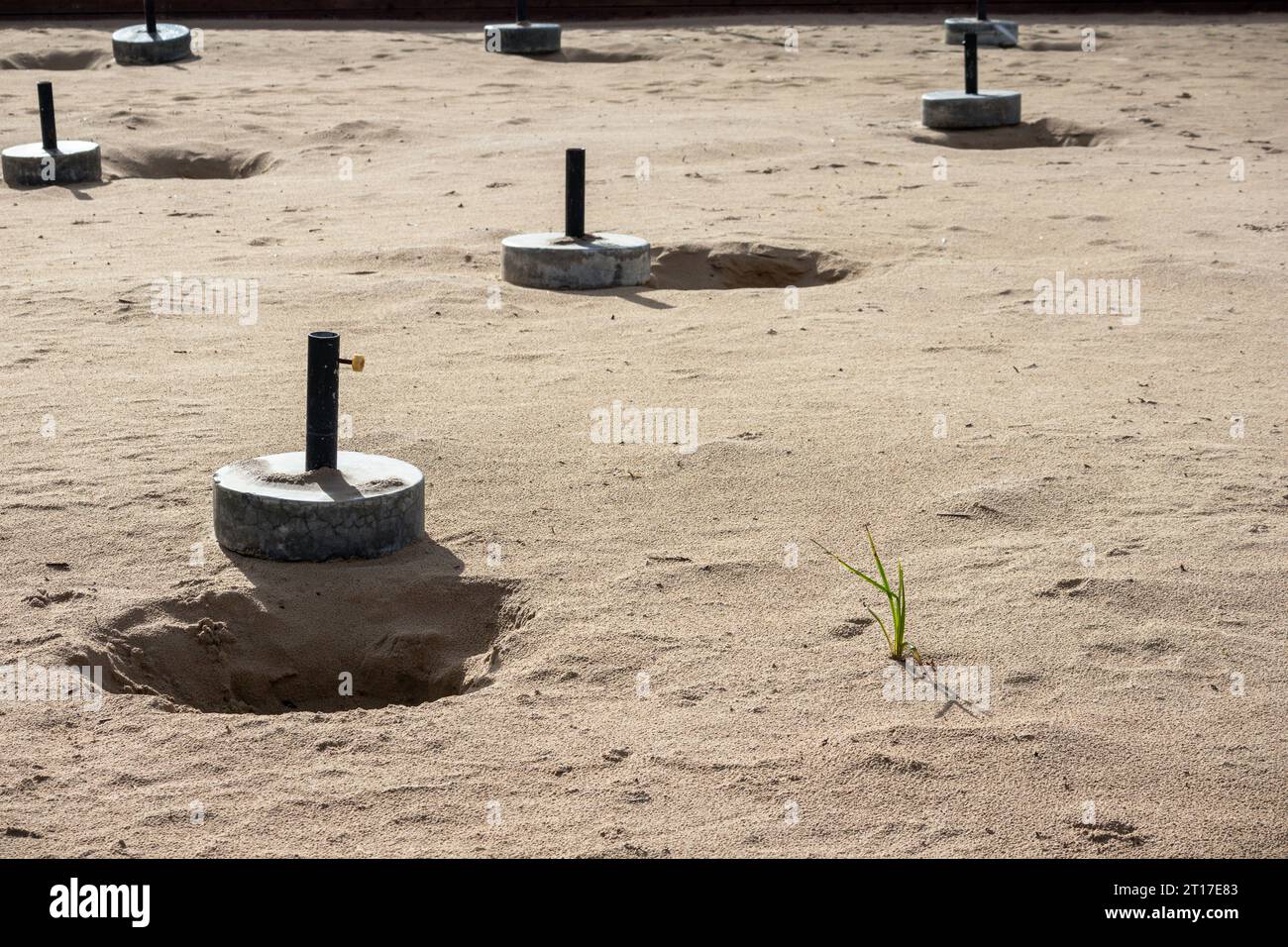 Concreted concrete posts with metal rod in sea sand Stock Photo - Alamy