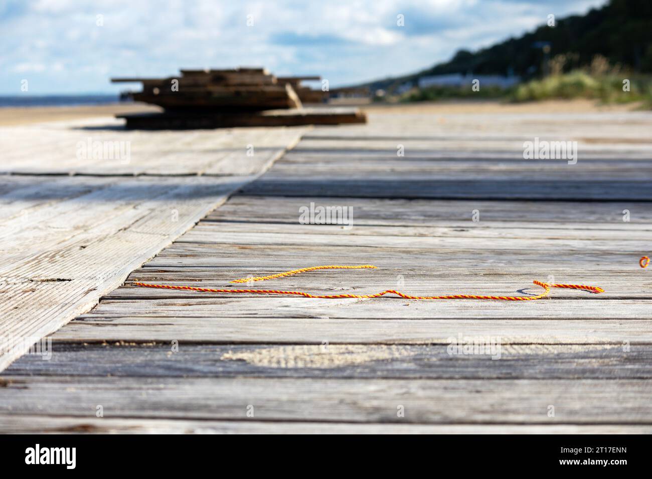 A stack of wooden planks placed on the edge of the sea against a ...