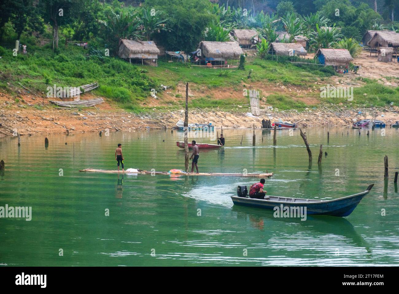 Indigenous men catching fish using net Stock Photo - Alamy