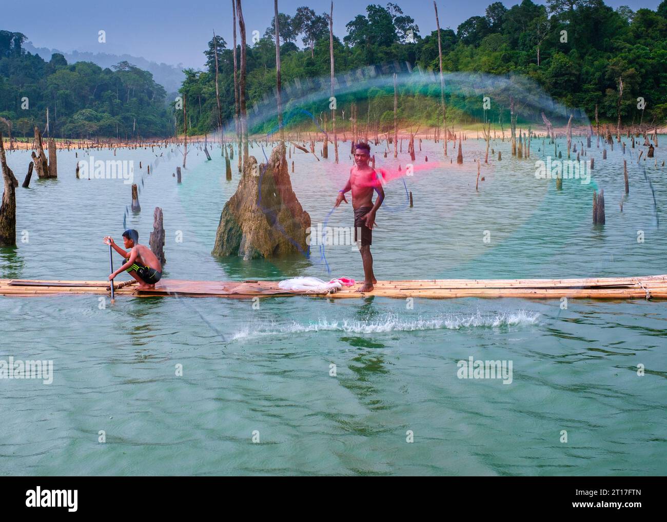 Indigenous men catching fish using net Stock Photo - Alamy