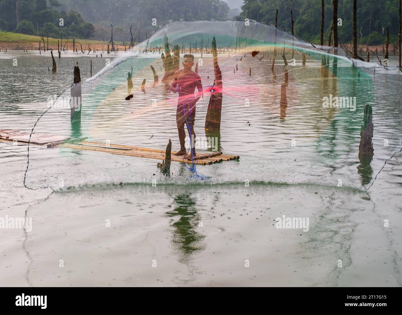 Indigenous men catching fish using net Stock Photo - Alamy