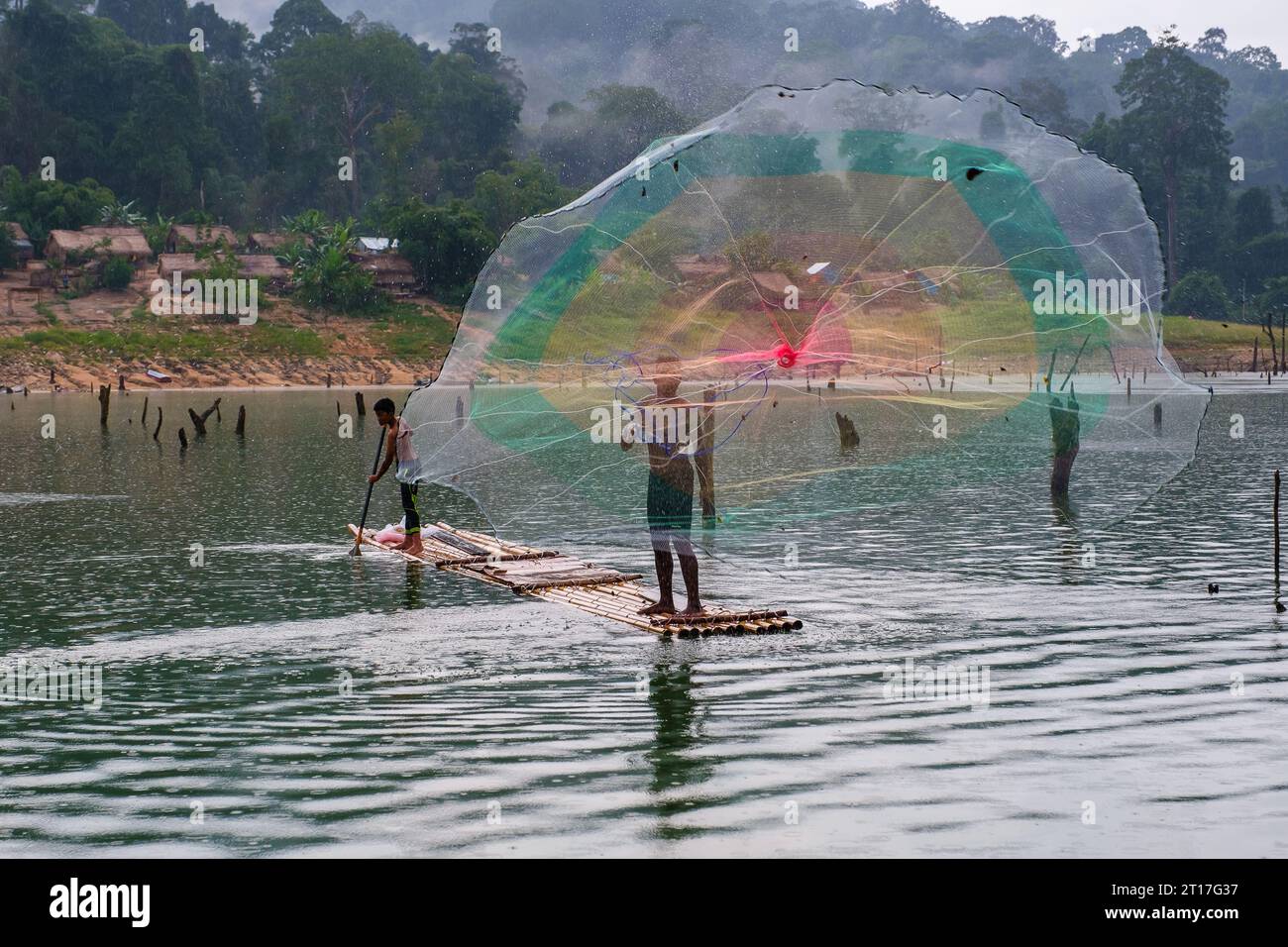 Indigenous men catching fish using net Stock Photo - Alamy