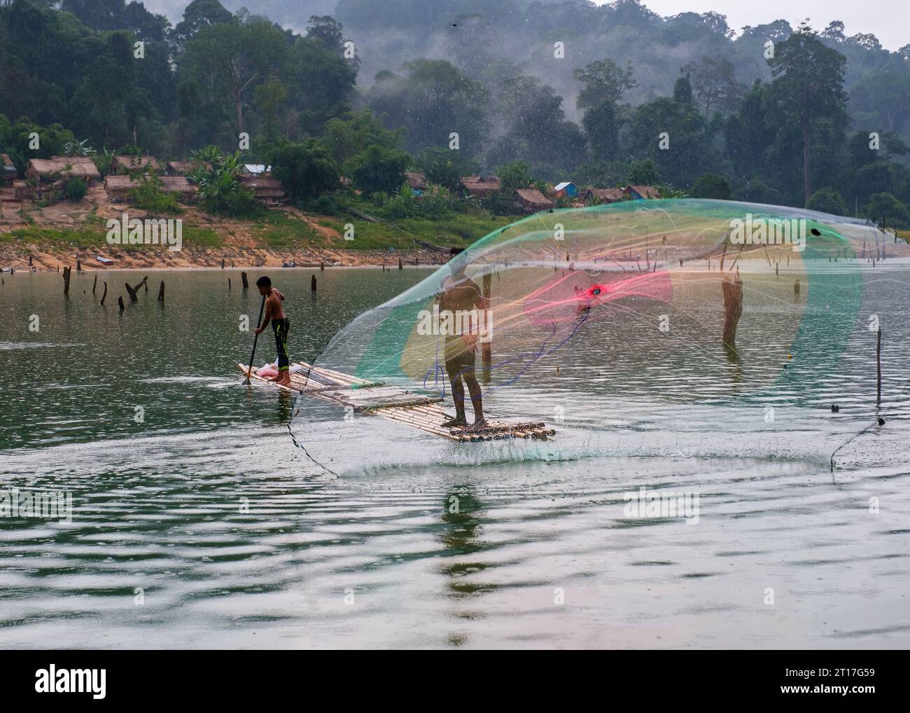 Indigenous men catching fish using net Stock Photo - Alamy