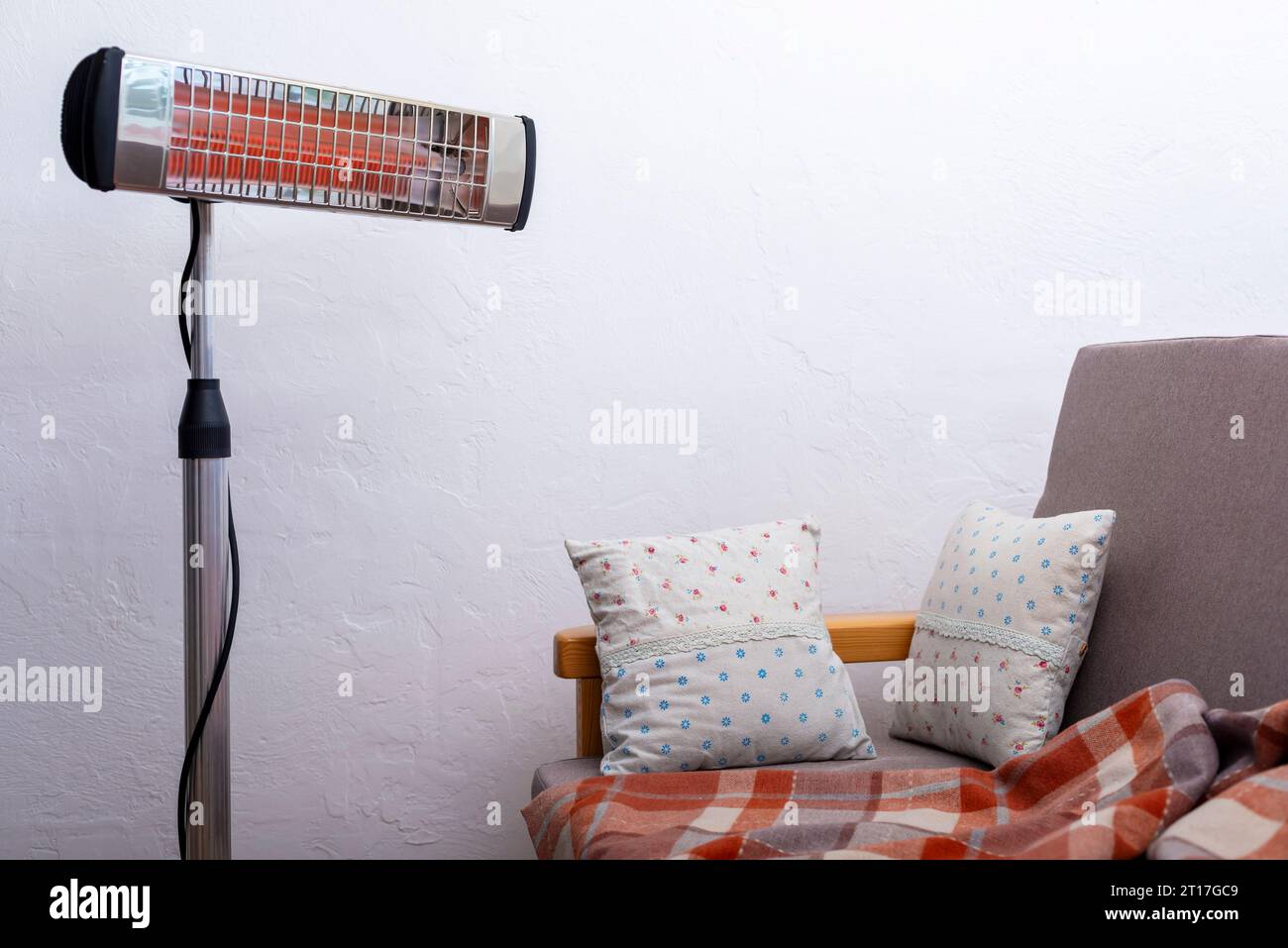 Electric infrared heater warming up living room with sofa and potted ...