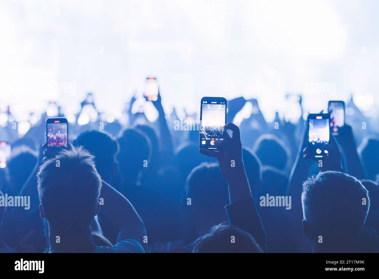 People taking pictures and recording at the big concert. Close-up shot ...