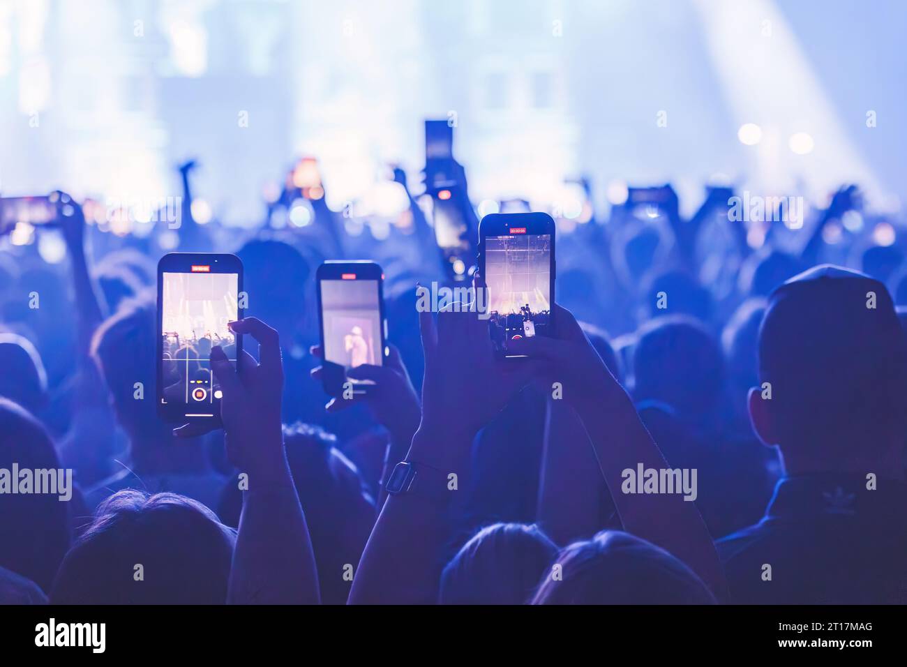 People taking pictures and recording at the big concert. Close-up shot ...