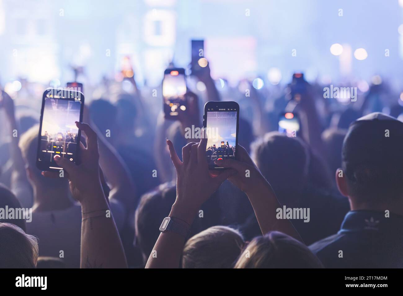 People taking pictures and recording at the big concert. Close-up shot ...