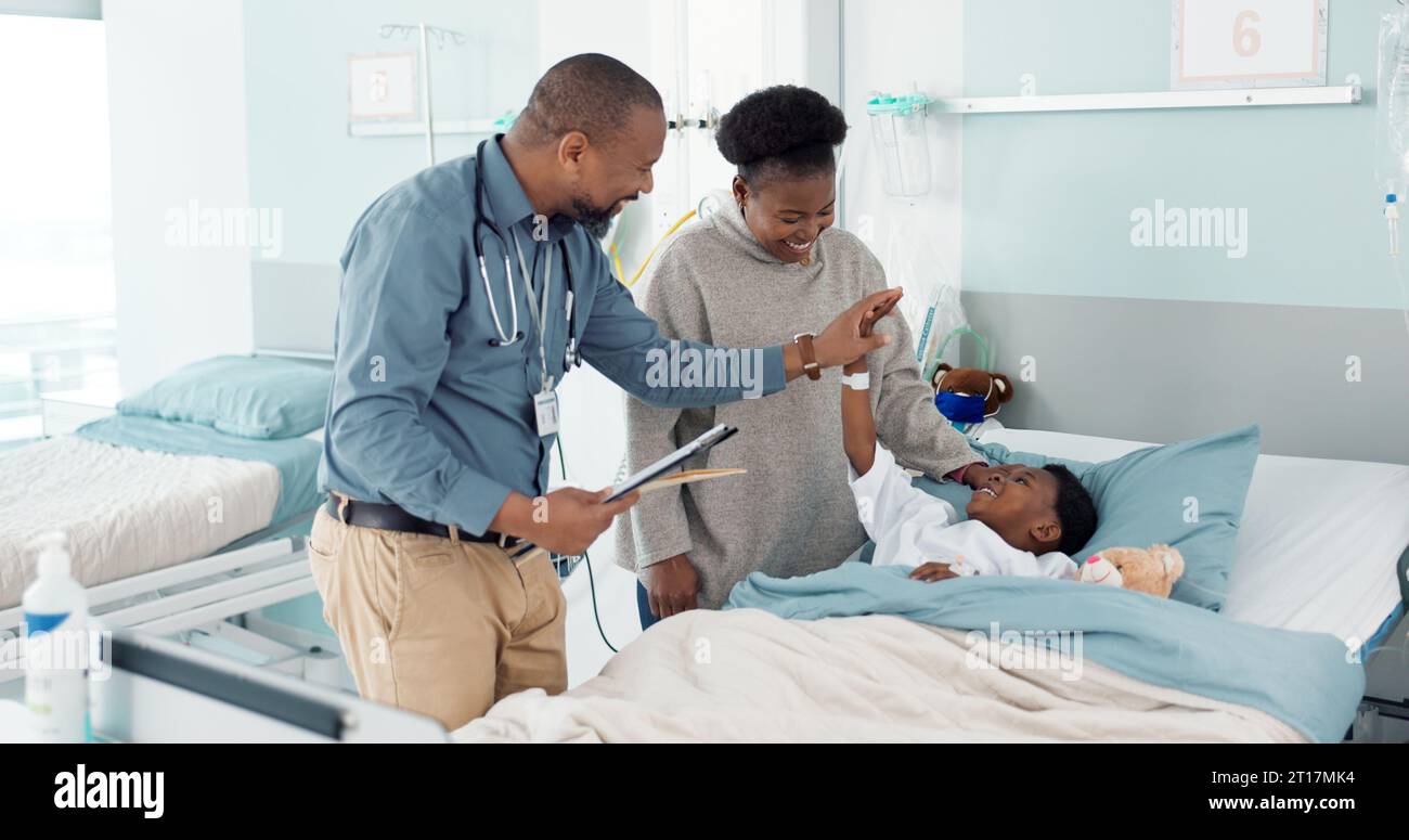 Doctor, high five and child in hospital, bed or healing in clinic with ...