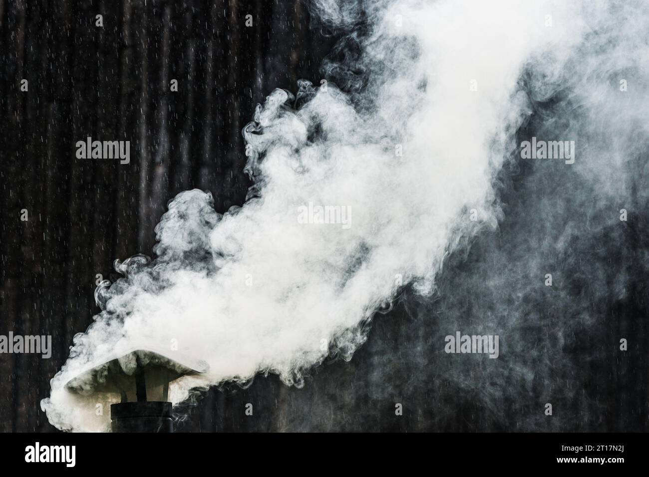 A chimney releases smoke in the rain Stock Photo - Alamy