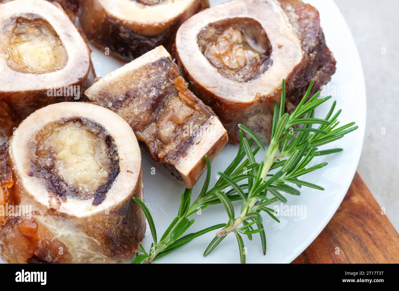 Roasted marrow bones on a white plate with rosemary garnish Stock Photo ...