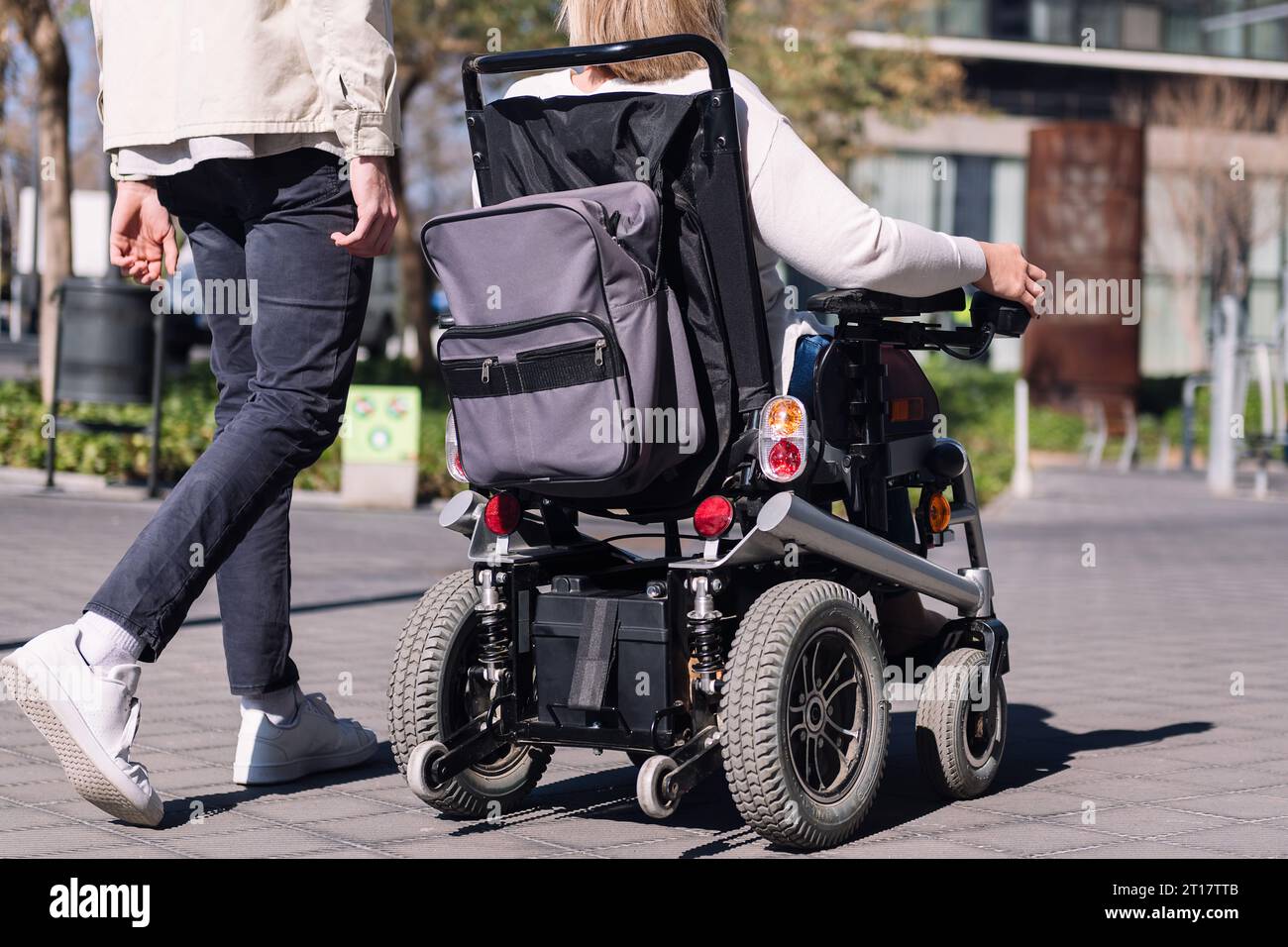woman using wheelchair with a man taking a walk Stock Photo - Alamy