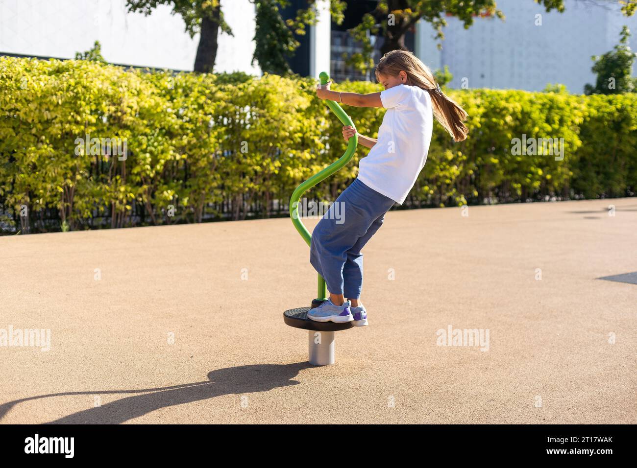 Girl playing on a swing in the park Stock Photo - Alamy