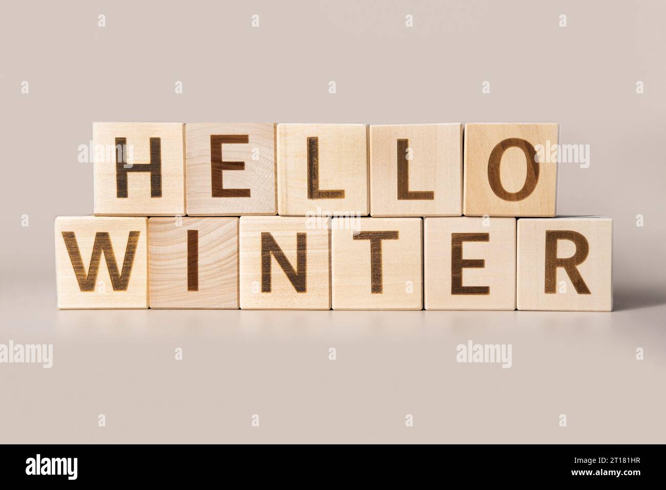 The Word Hello Winter on wooden cubes on a beige neutral studio ...