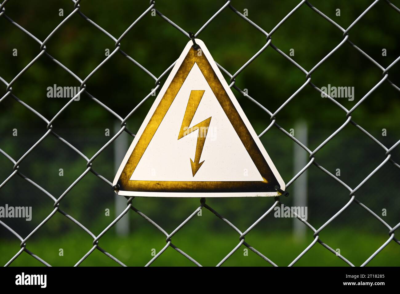 Schild mit Strompfeil an einem Zaun, Symbolfoto Stromversorgung und ...