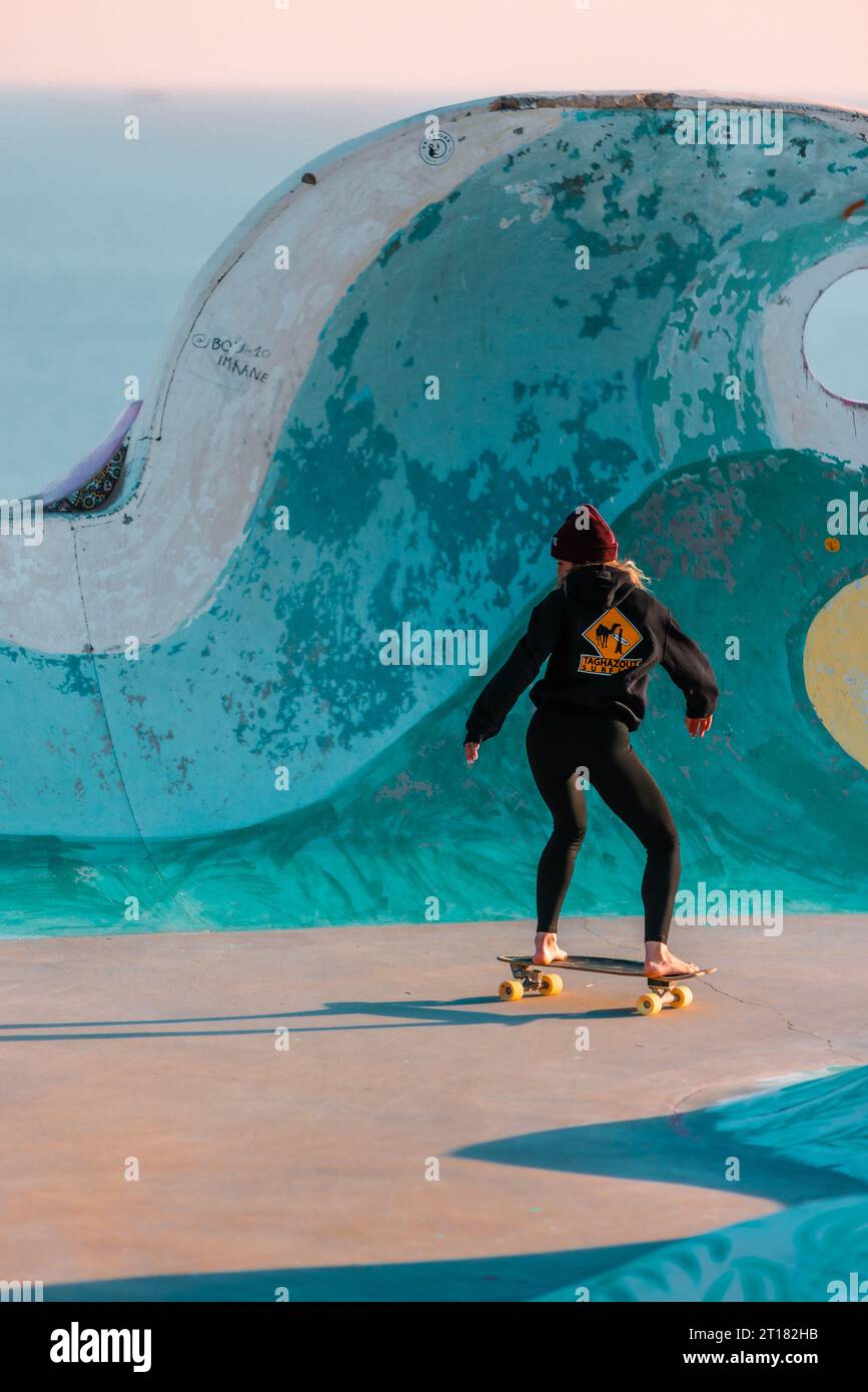 An active young man performing a skateboarding trick on a ramp in ...