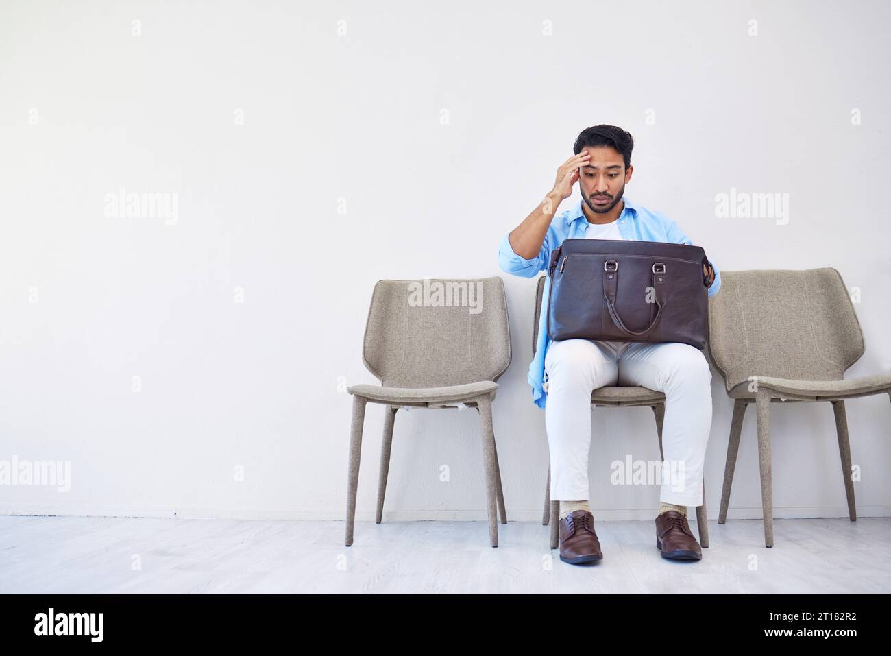 Bag, stress and man search in waiting room for interview, hiring and recruitment with lost ...