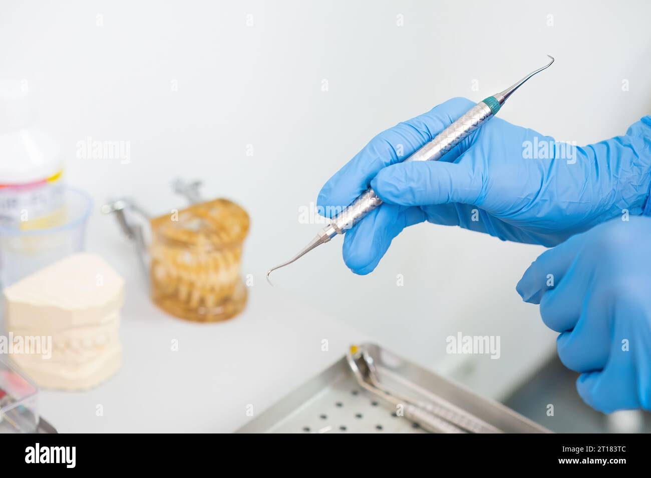 A dentist's hands holding dental instruments for teeth treatment, with ...