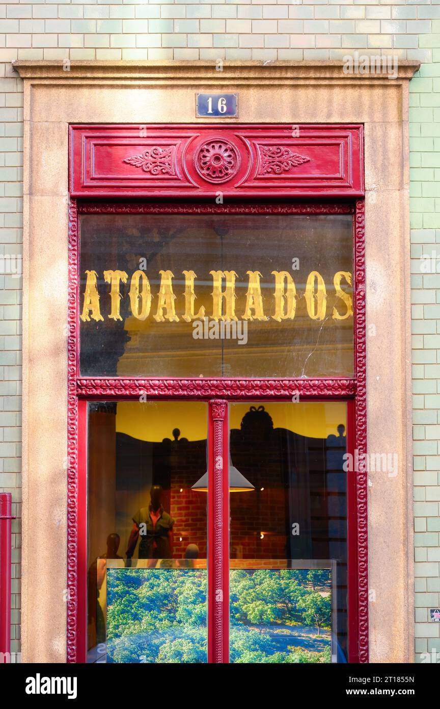 Ancient door in a tiled wall or facade of an old building. Glass window ...