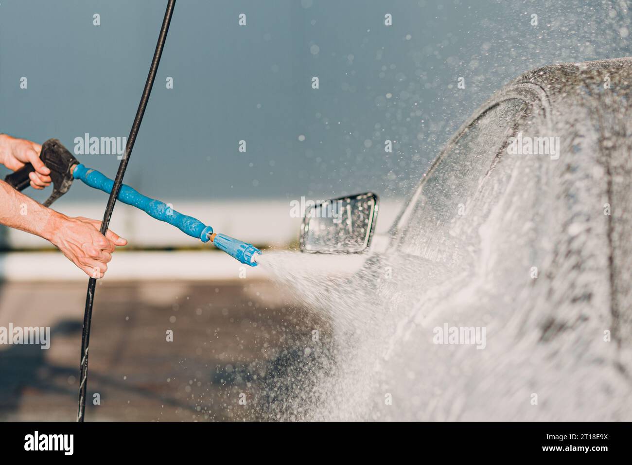 Worker washing car at self-service car wash Stock Photo - Alamy