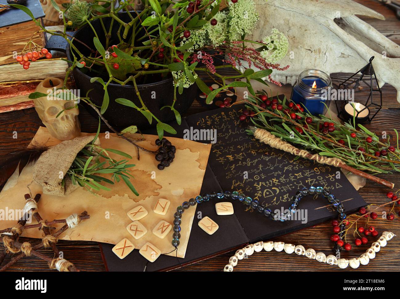 Magic book of spells with runes and herbs on altar table. No foreign ...