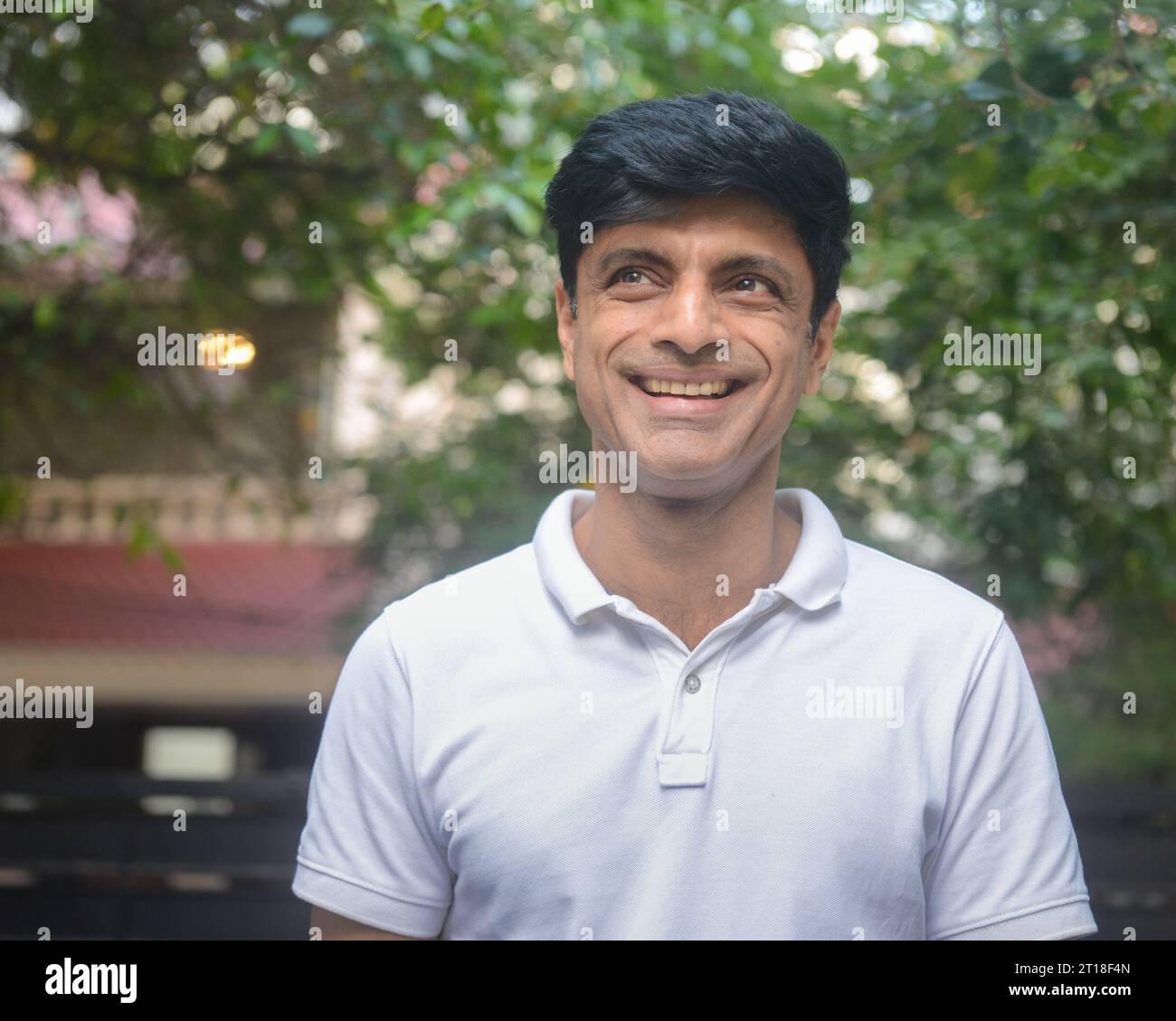A smart middle-aged fit Indian man in a white t-shirt outdoors Stock ...