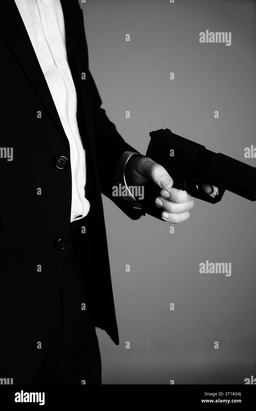 Retro secret agent with pistol revolver gun in hand in vintage crime ...