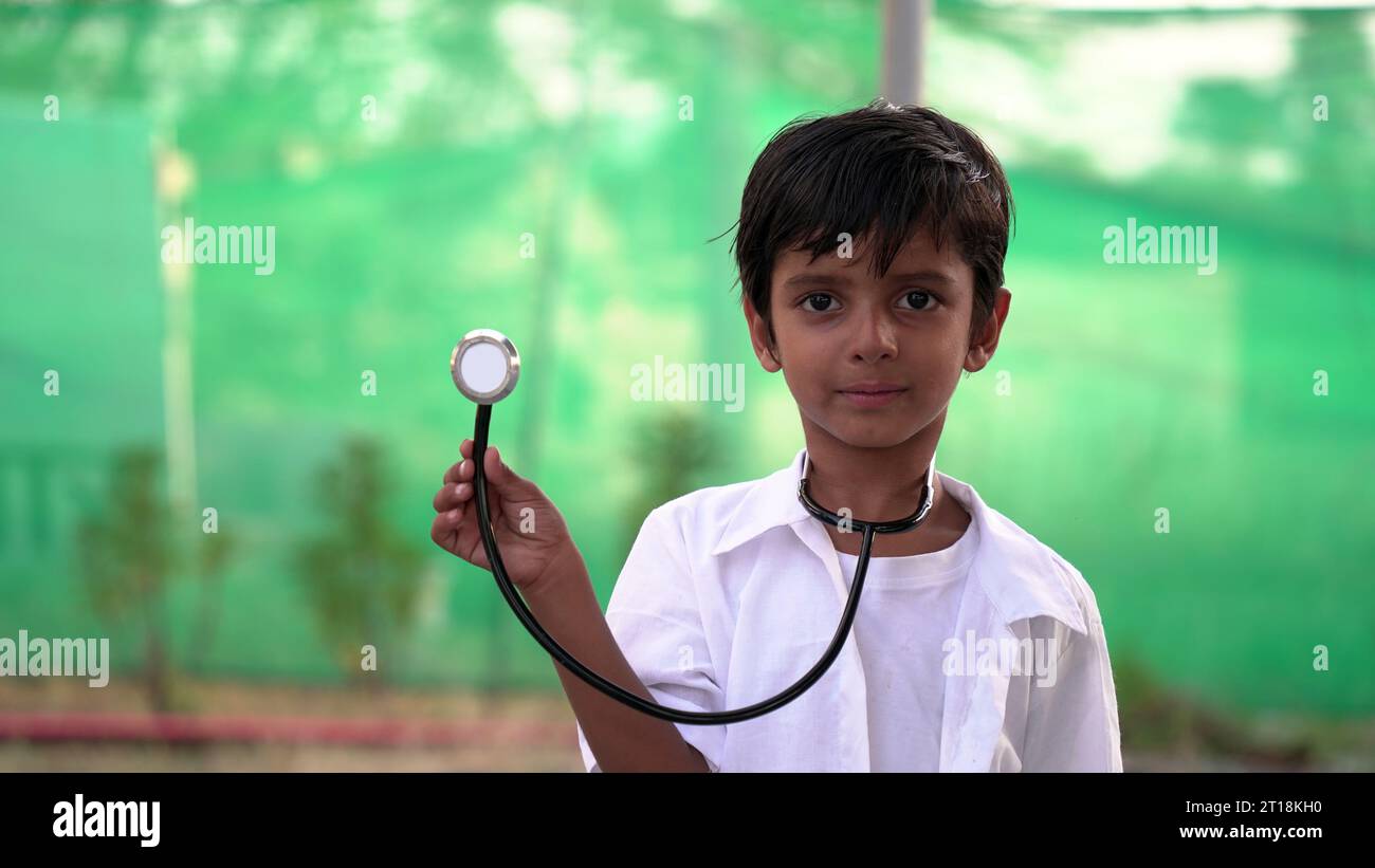 Cute small Indian kid boy wear medical uniform holding stethoscope ...