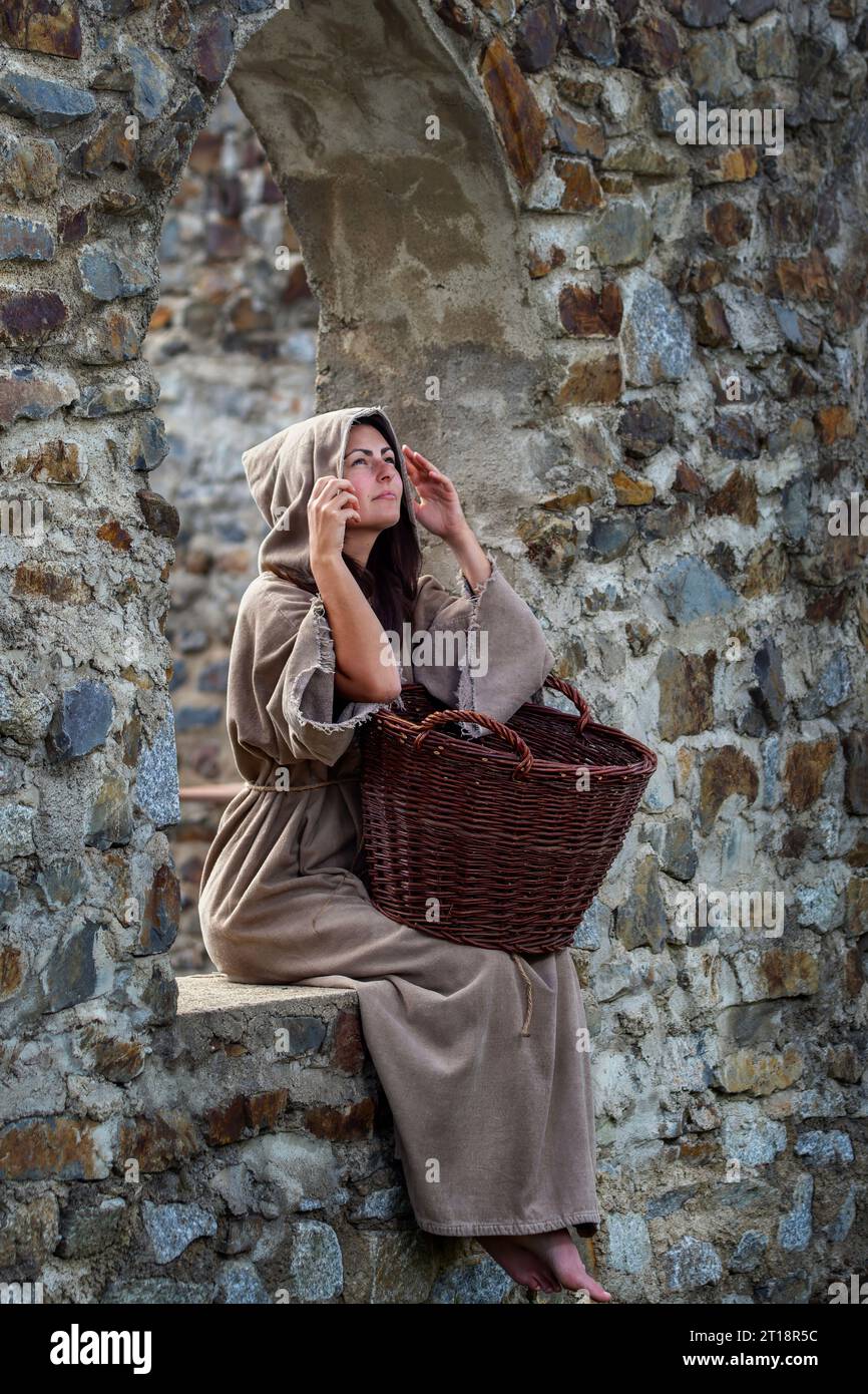 Pretty peasant woman in the Middle Ages taking a break at the castle ...