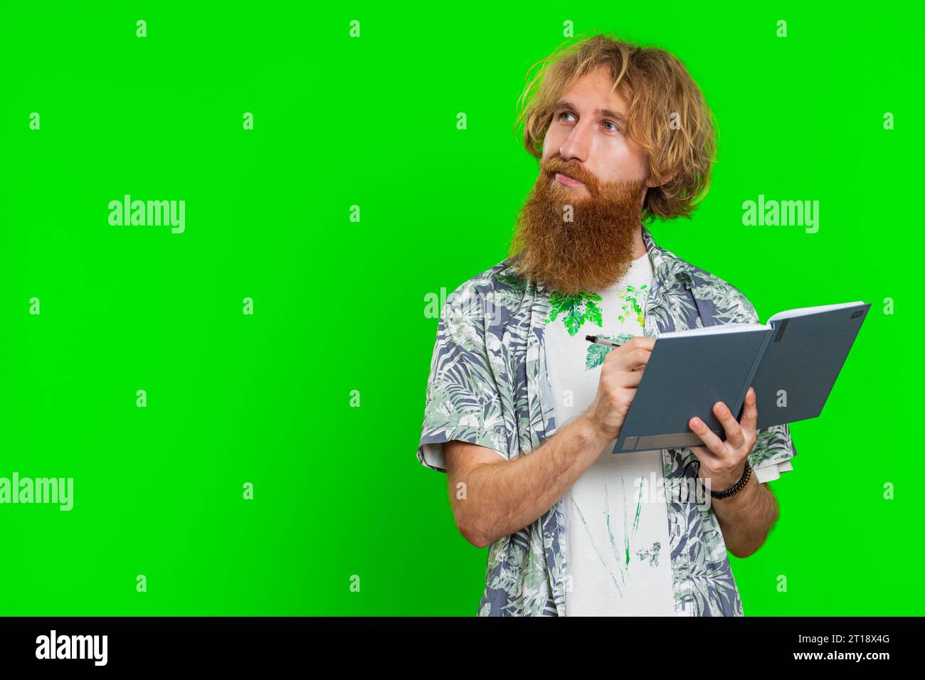 Thoughtful journalist young man making notes, writing down thoughts ...