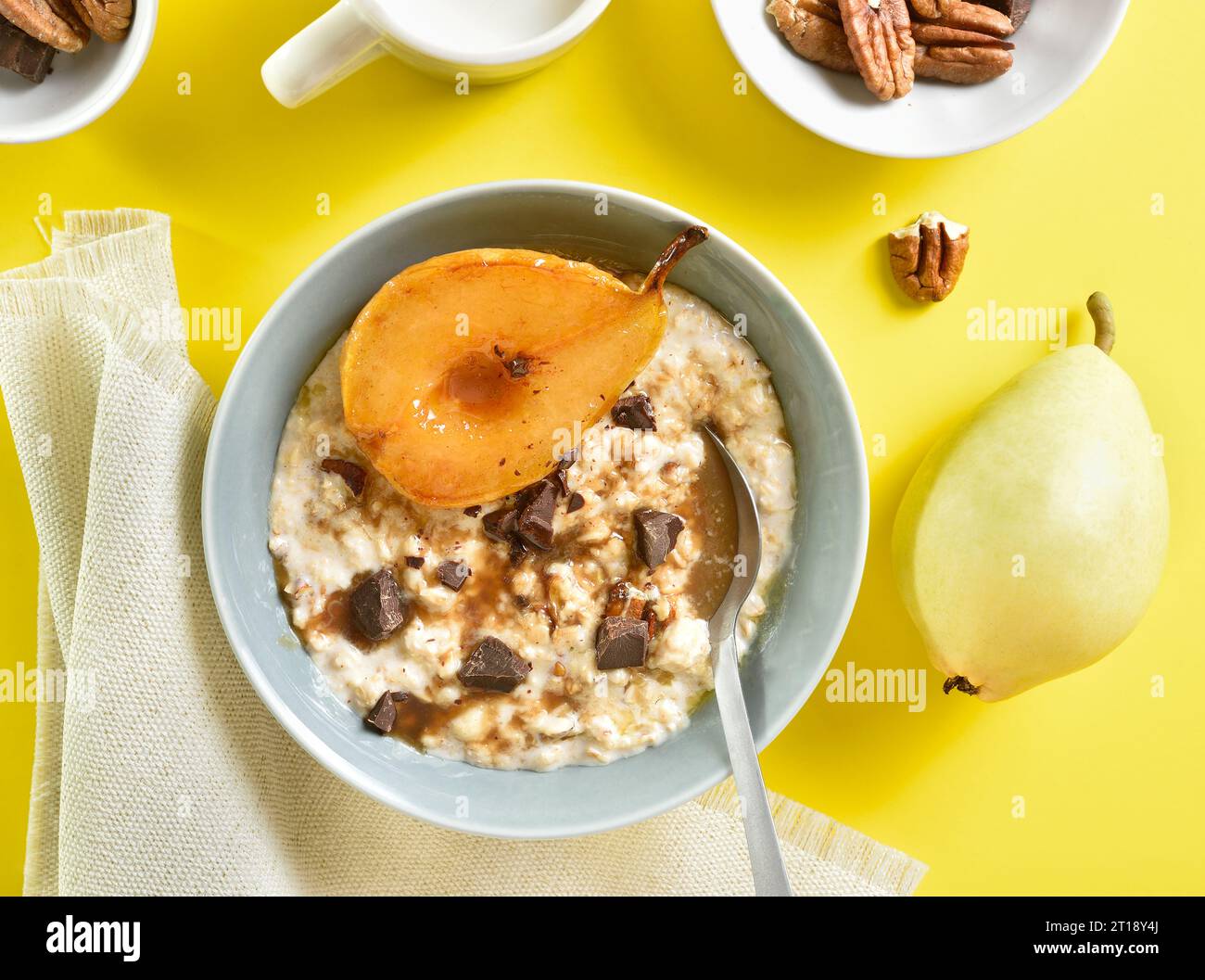 Oat porridge with caramelized pear and chocolate pieces in bowl over ...