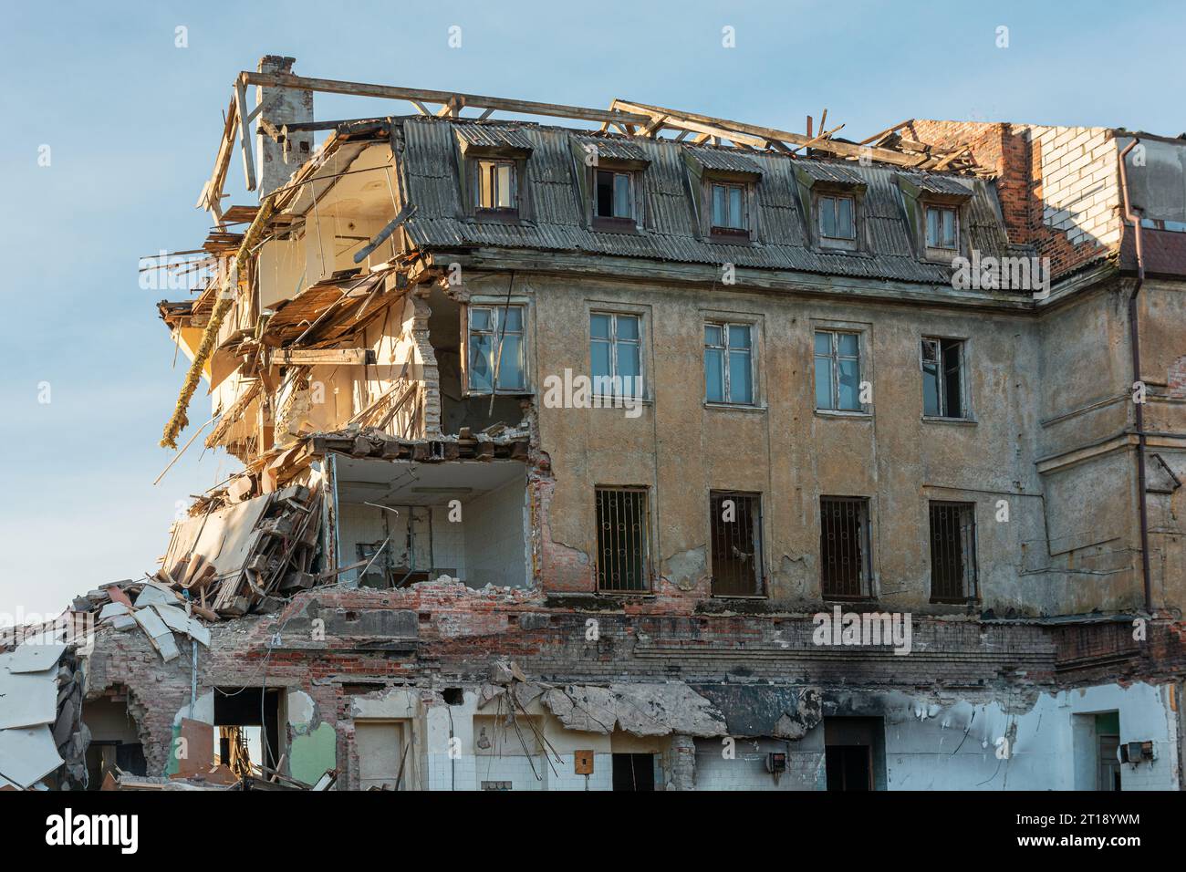 A large destroyed building with broken apartments and a pile of ...