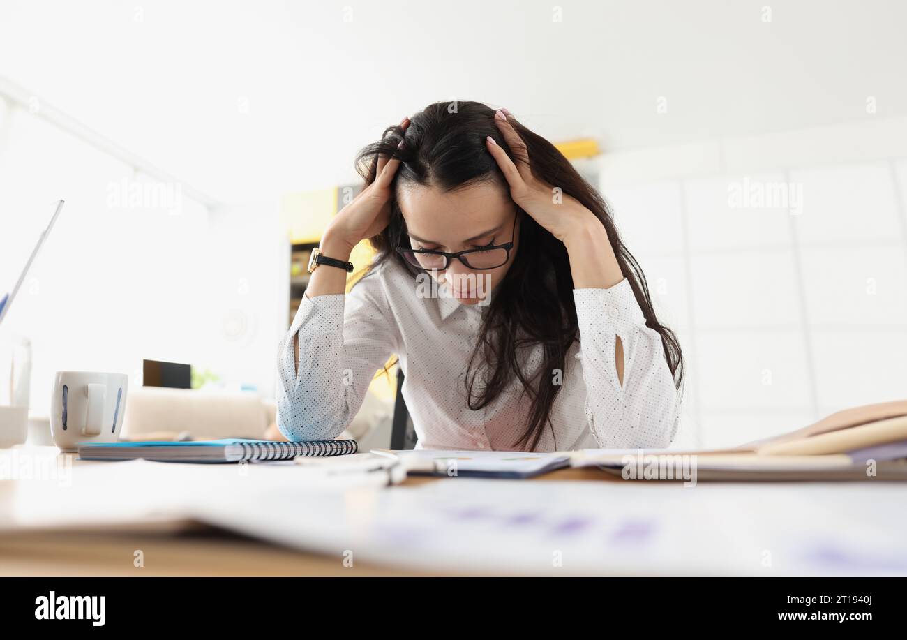 Tired woman bowed her head over her desk with documents Stock Photo - Alamy