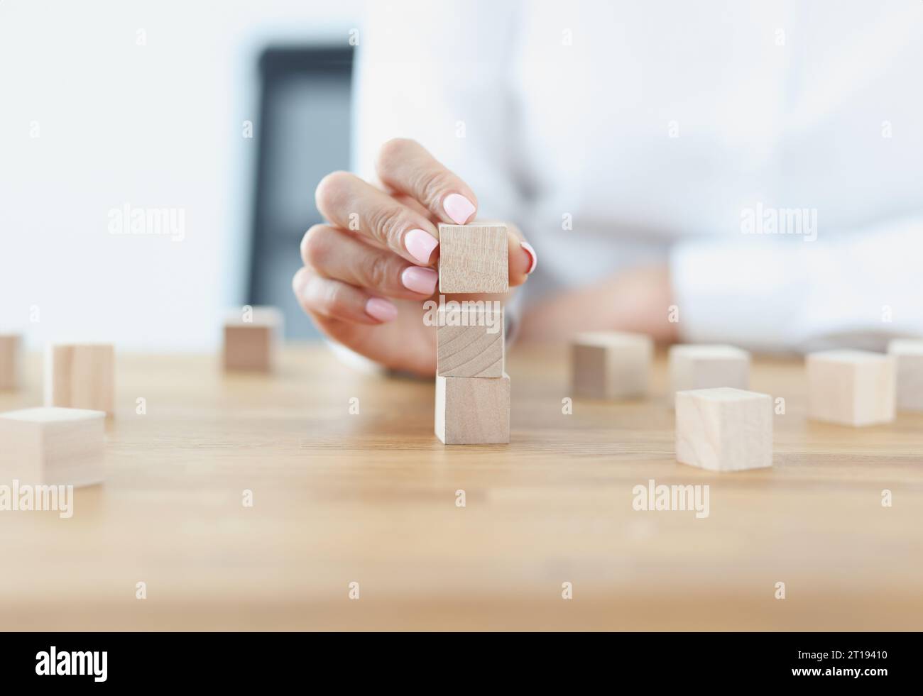 Female hand builds tower from wooden cubes Stock Photo - Alamy