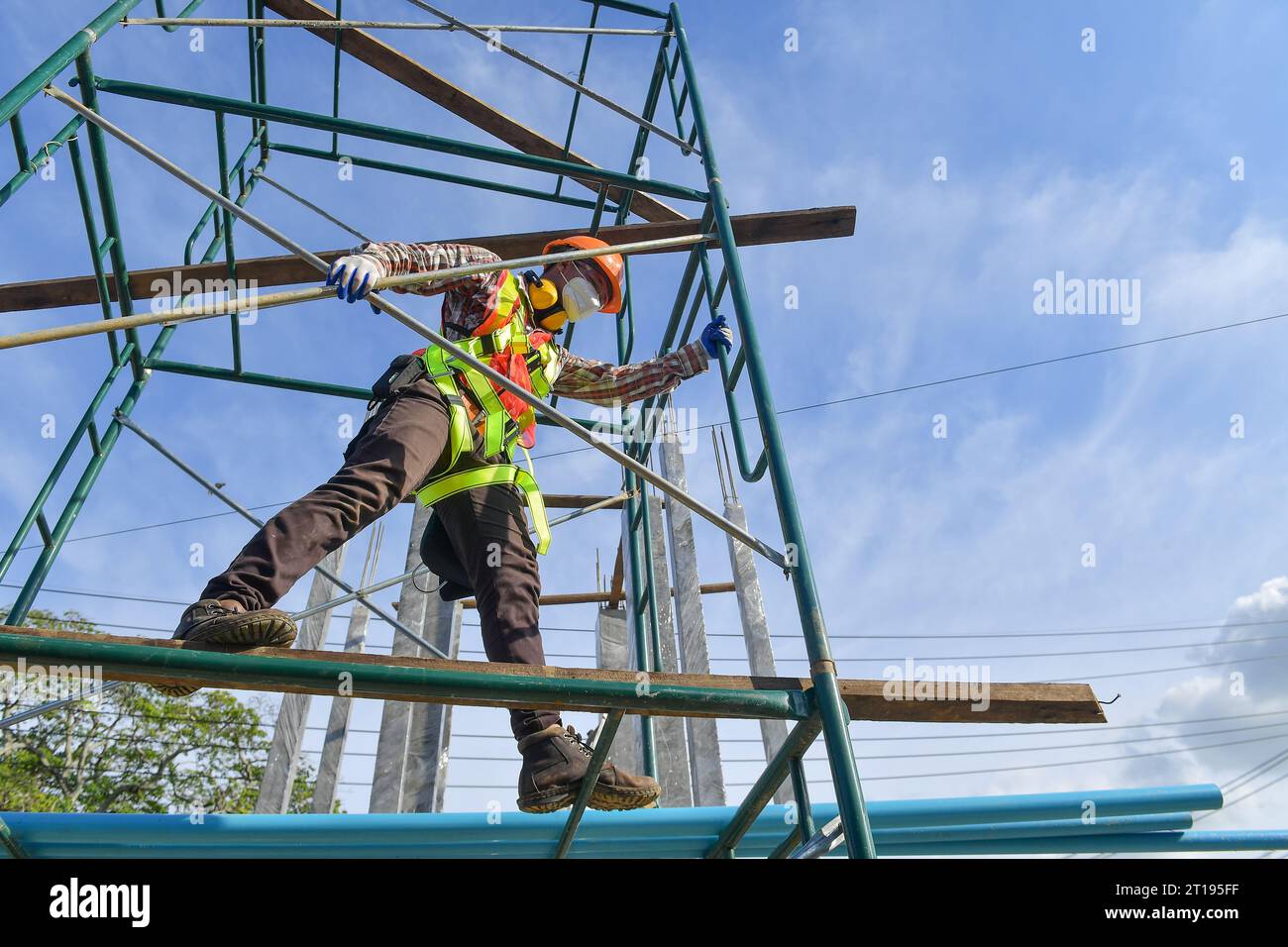 Low angle view of a Construction worker in a face mask standing on ...
