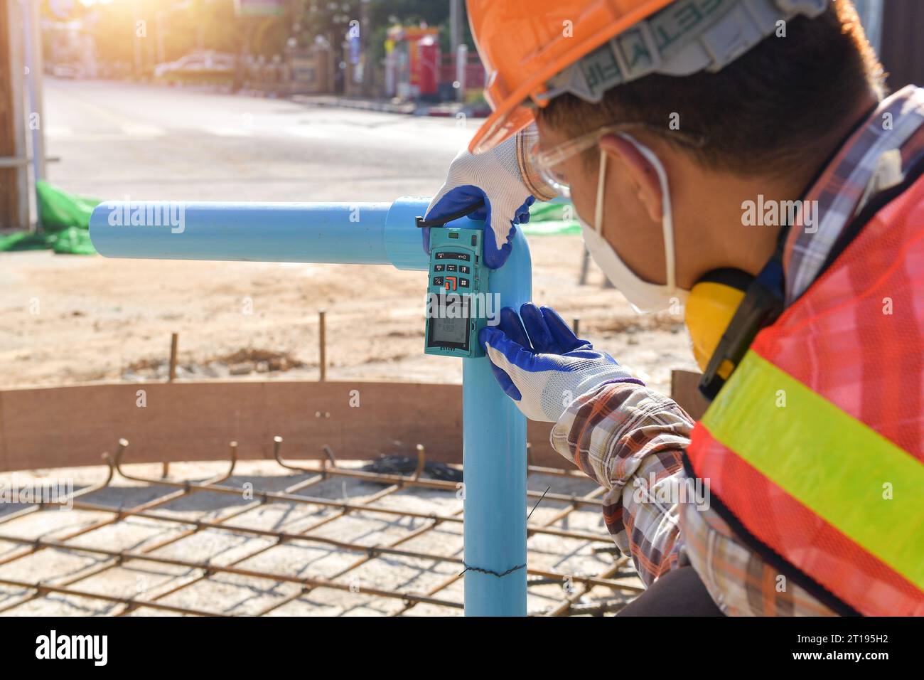 Construction worker using a Laser measuring tool on a construction site ...