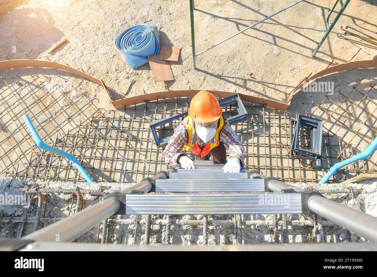 Overhead view of a construction worker climbing a ladder, Thailand ...
