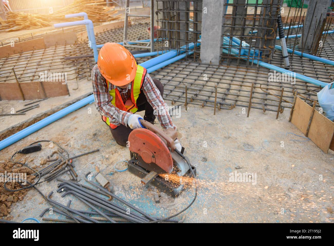Construction worker cutting steel with a grinder on a construction site ...