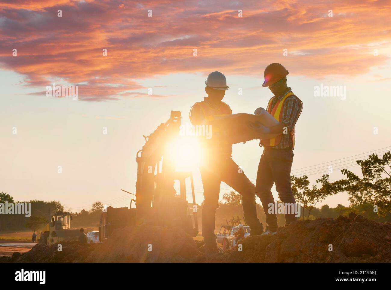 Two construction workers looking at plans on a construction site ...